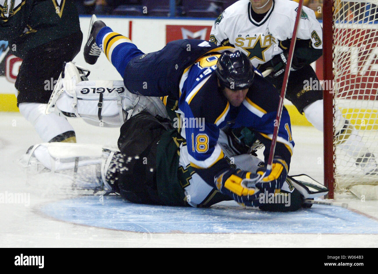 St. Louis Blues Mike Sillinger bowls over Dallas Stars goaltender Johan ...