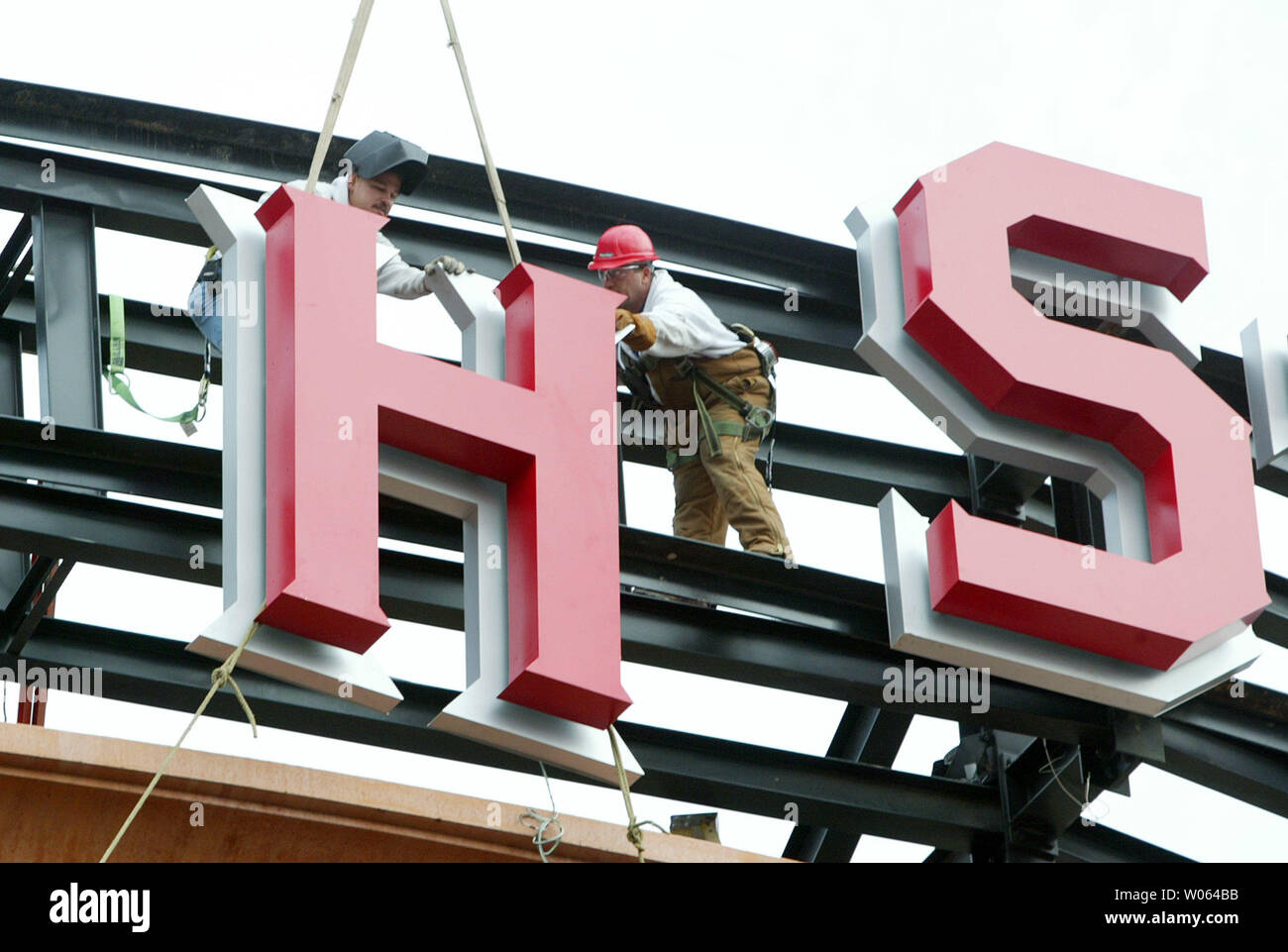 Construction workers guide the "H" of Busch into place atop the new ...