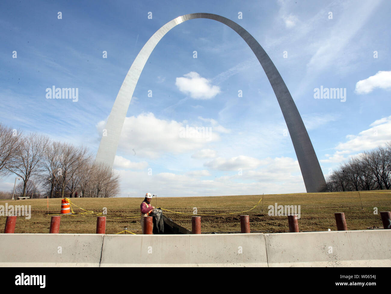 A construction worker covers newly installed steel posts on the grounds ...