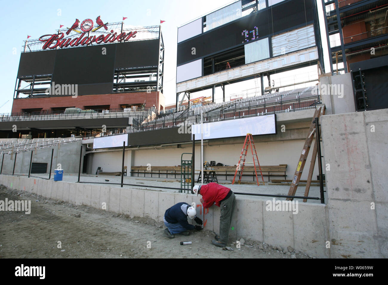 Construction worker measure the wall in right field next to the St ...