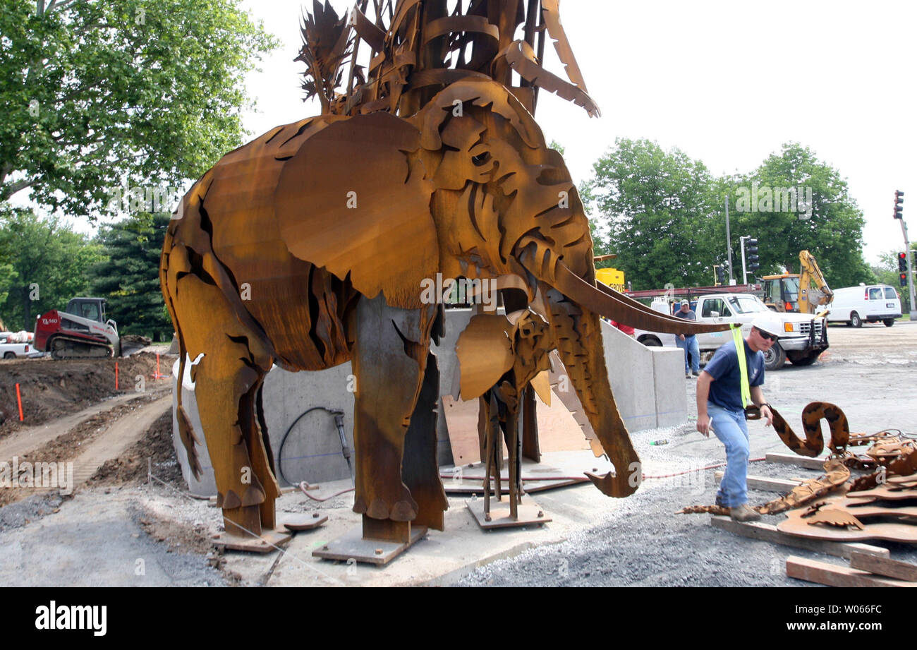 A workman ducks under the trunk of an elephant as work continues on the ...
