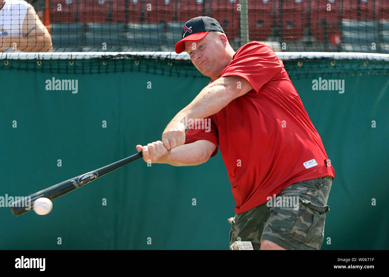 St. Louis Rams center Andy McCollum takes a swing during a batting ...