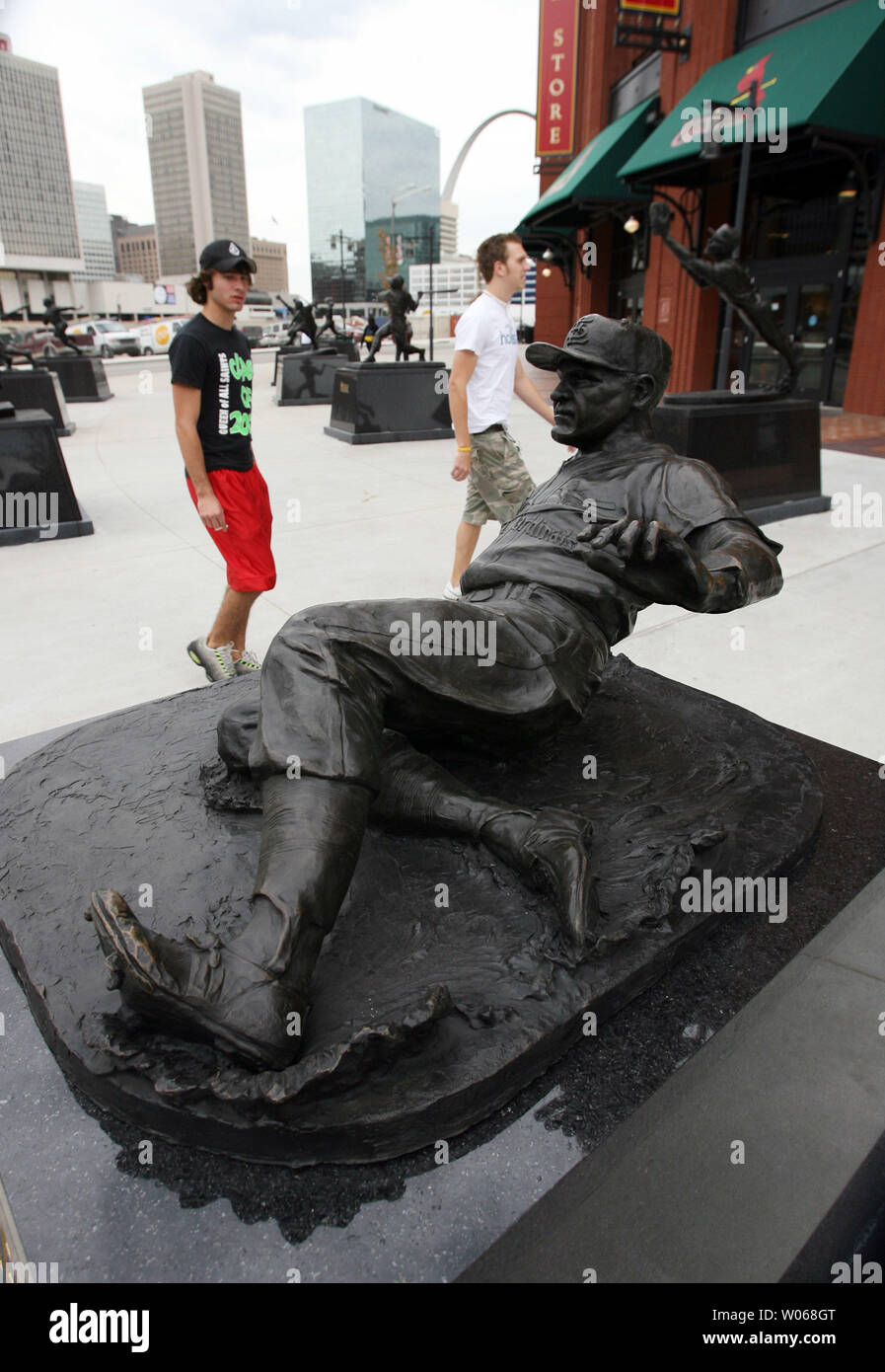 Visitors to Busch Stadium walk past a statue of National Baseball Hall ...