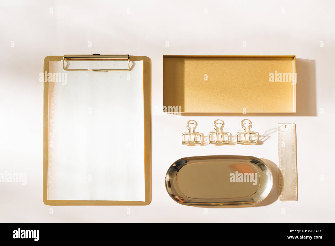 Flat lay of gold stationery on light background Stock Photo - Alamy