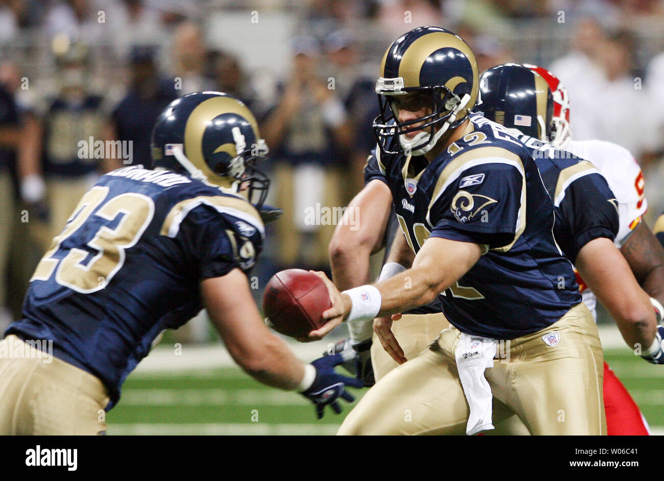 St. Louis Rams quarterback Gus Frerotte (R) hands the football off to ...