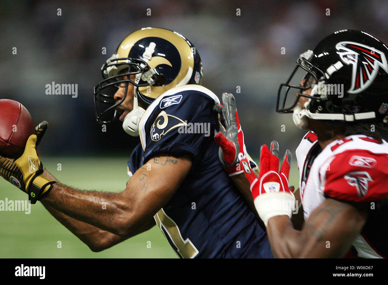 St. Louis Rams wide receiver Torry Holt (L) catches a football in front ...