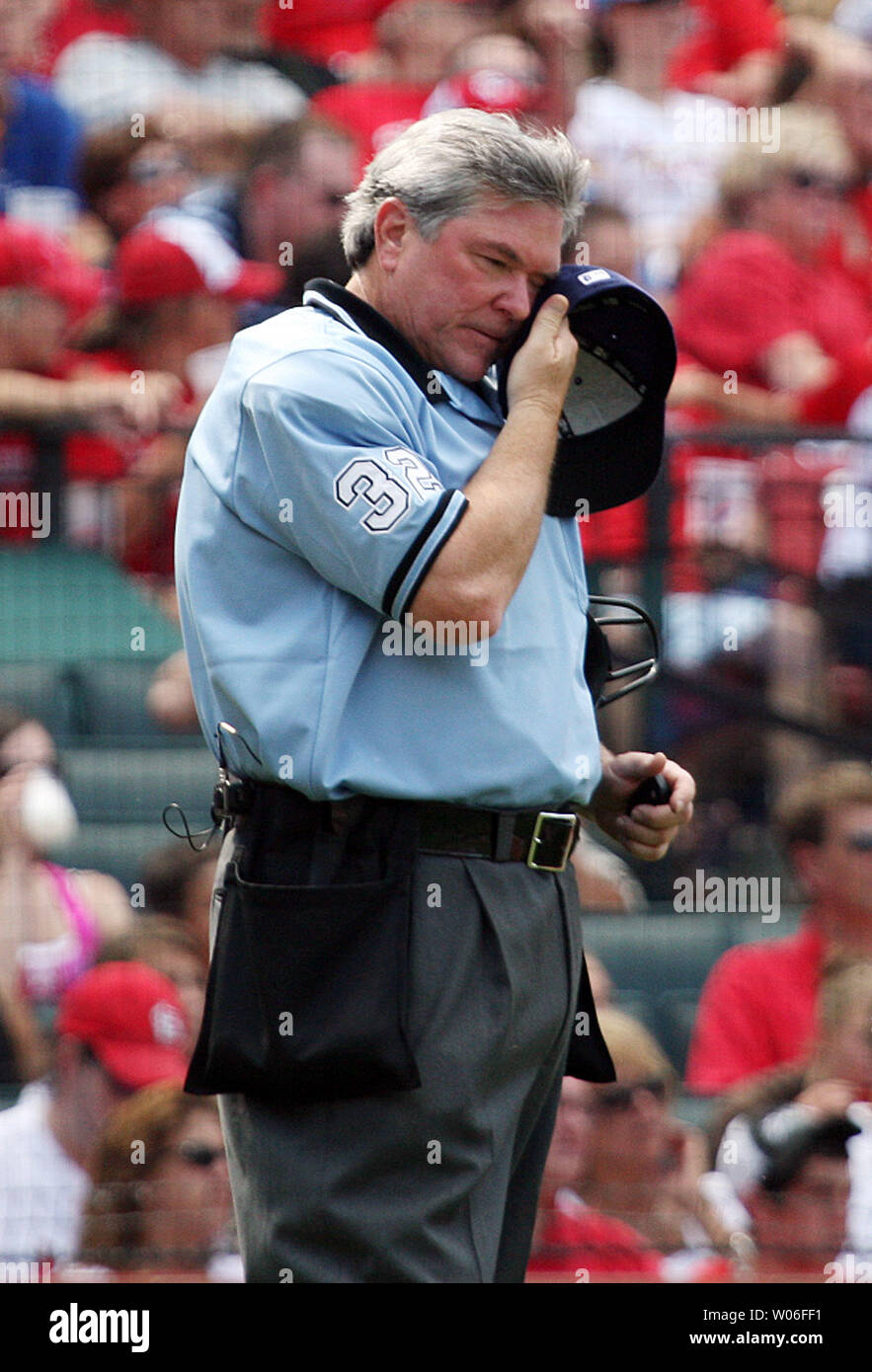 Homeplate umpire Dana DeMuth wipes his face with his cap between ...