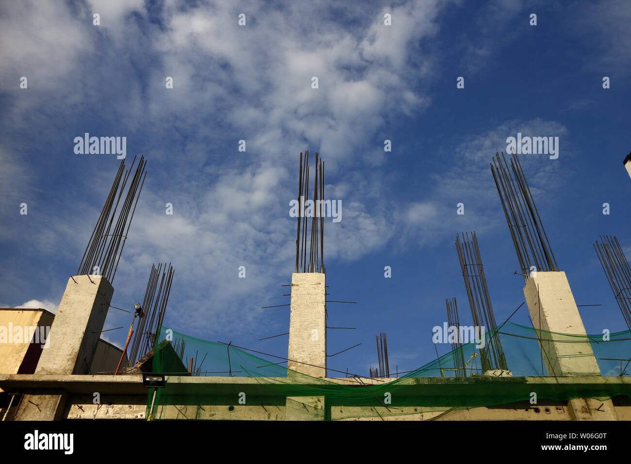 Photo of concrete and steel pillars of an unfinished building structure ...