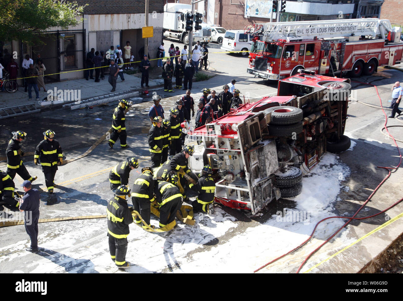 St. Louis firefighters work to clear the debris after two fire trucks ...