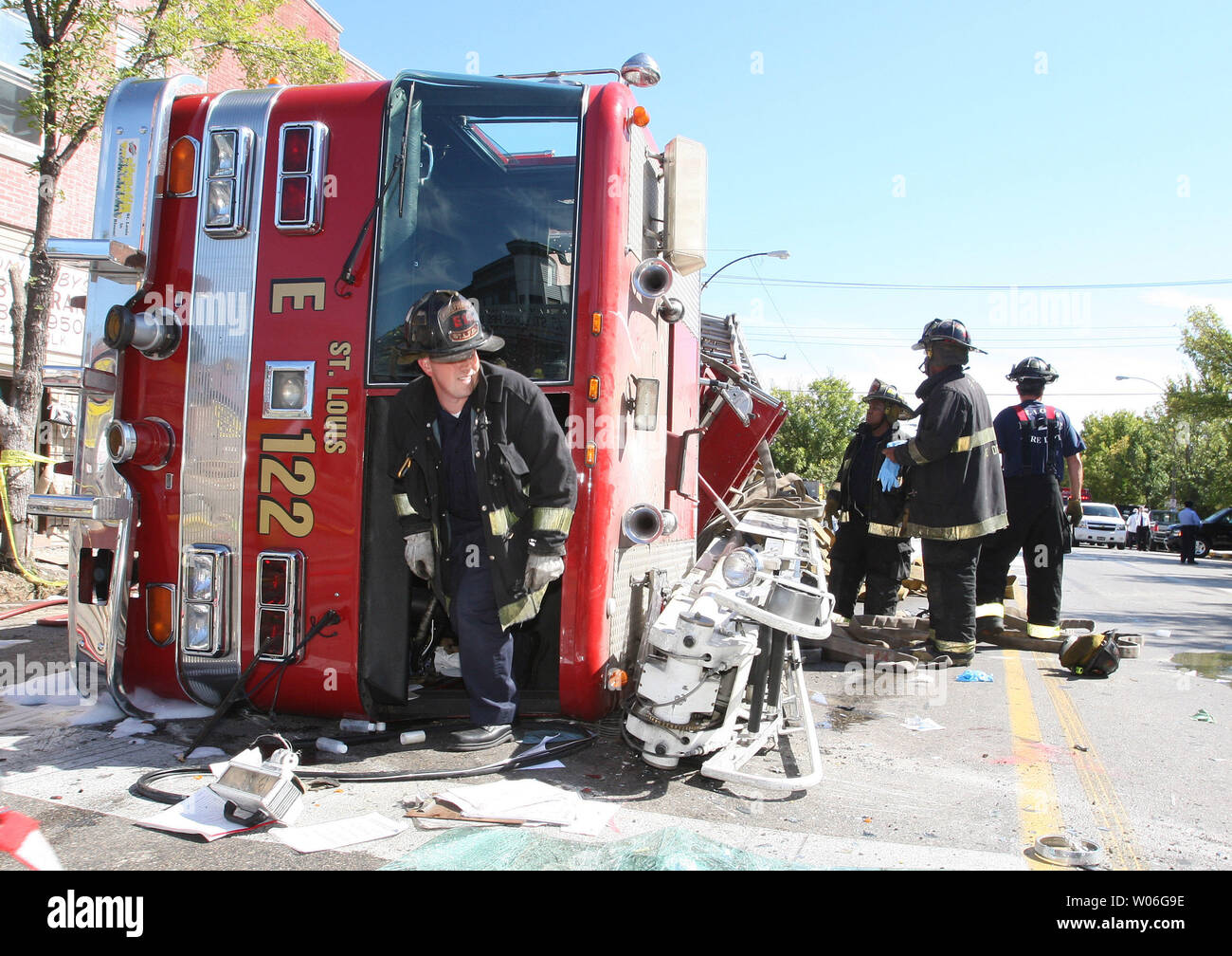 A St. Louis fireman emerges from the cab of a overturned fire truck ...