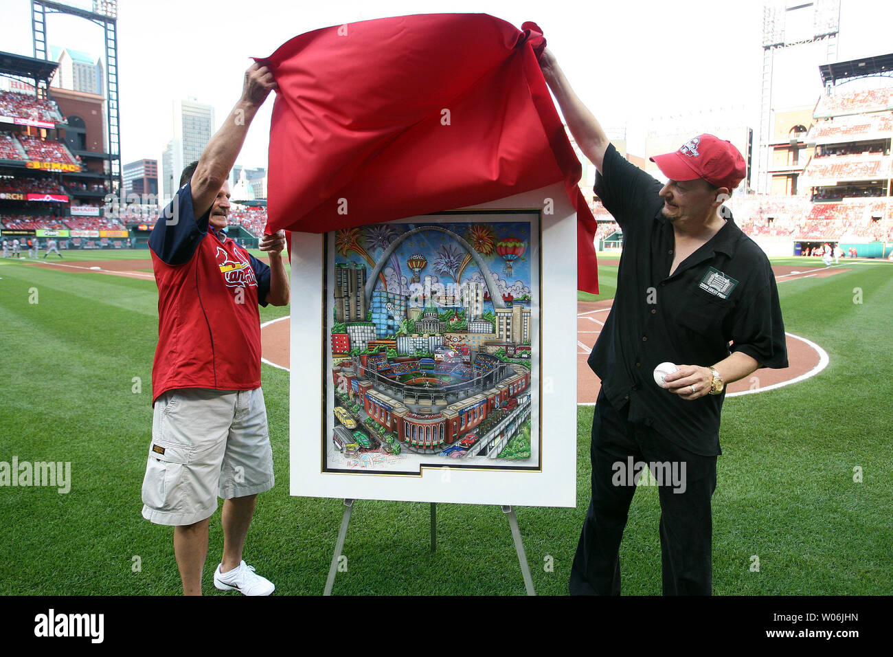 Former St. Louis Cardinals third baseman Ken Reitz (L) helps artist ...