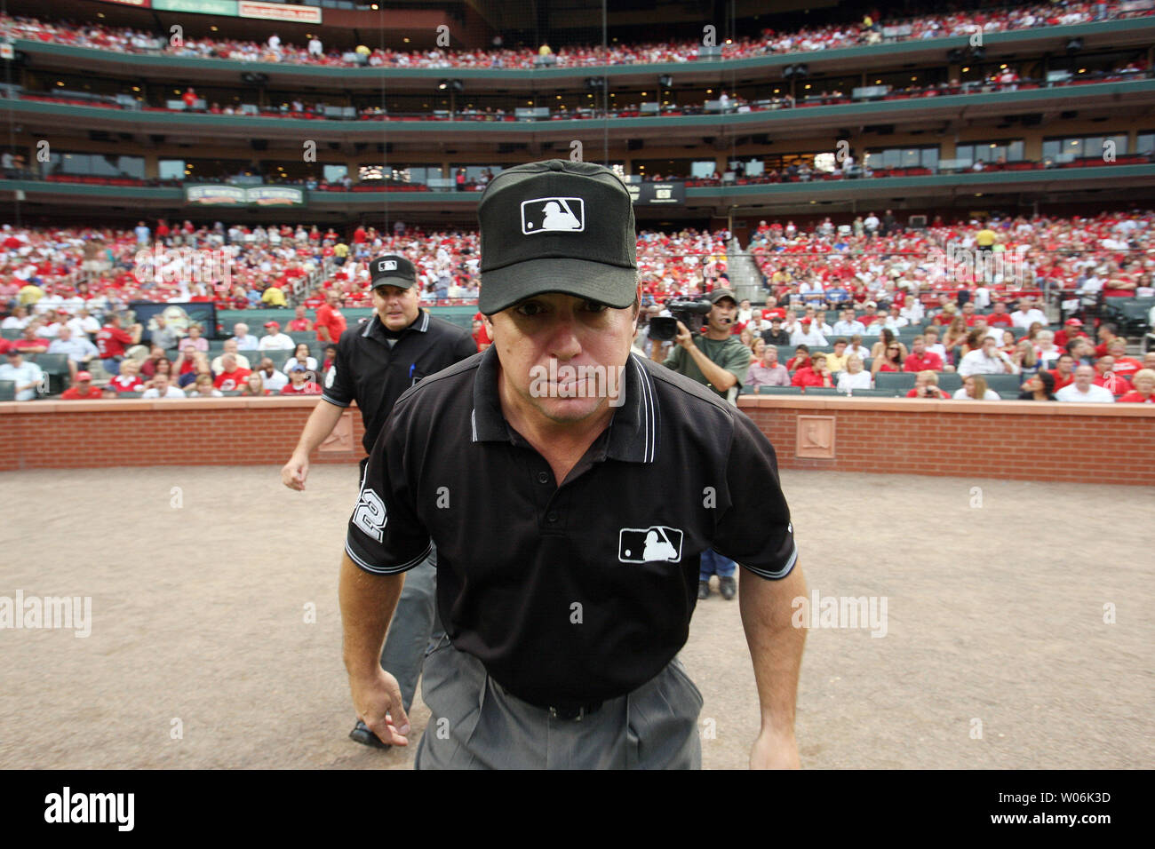Umpire Rob Drake gets a closer look at the camera lens as he enters the ...