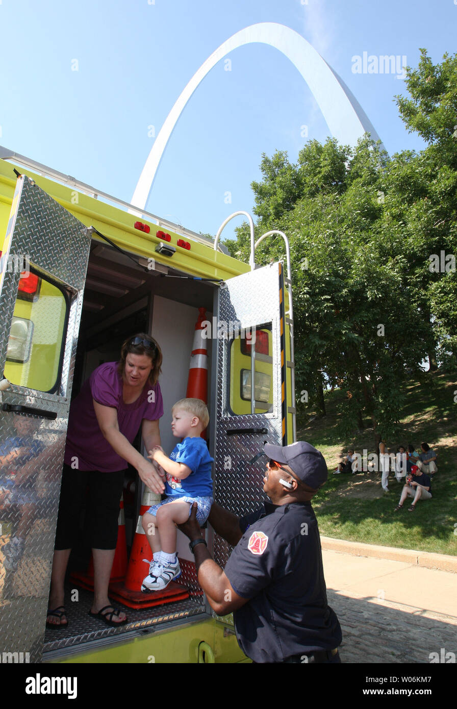 St. Louis firefighter Thomas Chatman helps Quinn Berning (2) of ...