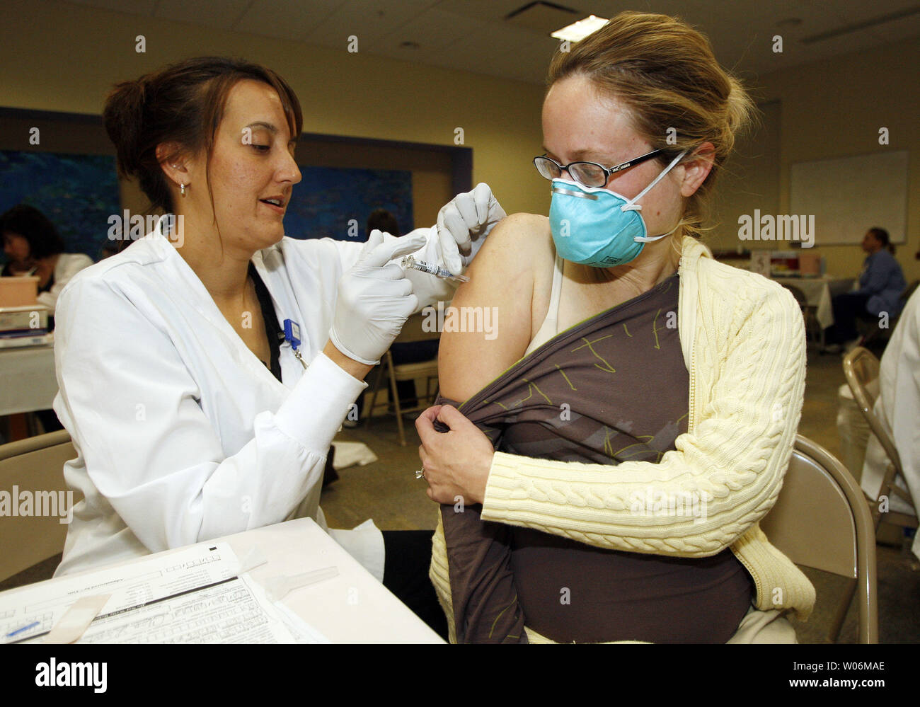 Patient Tina Smith holds receives an H1N1 flu vaccination from health ...