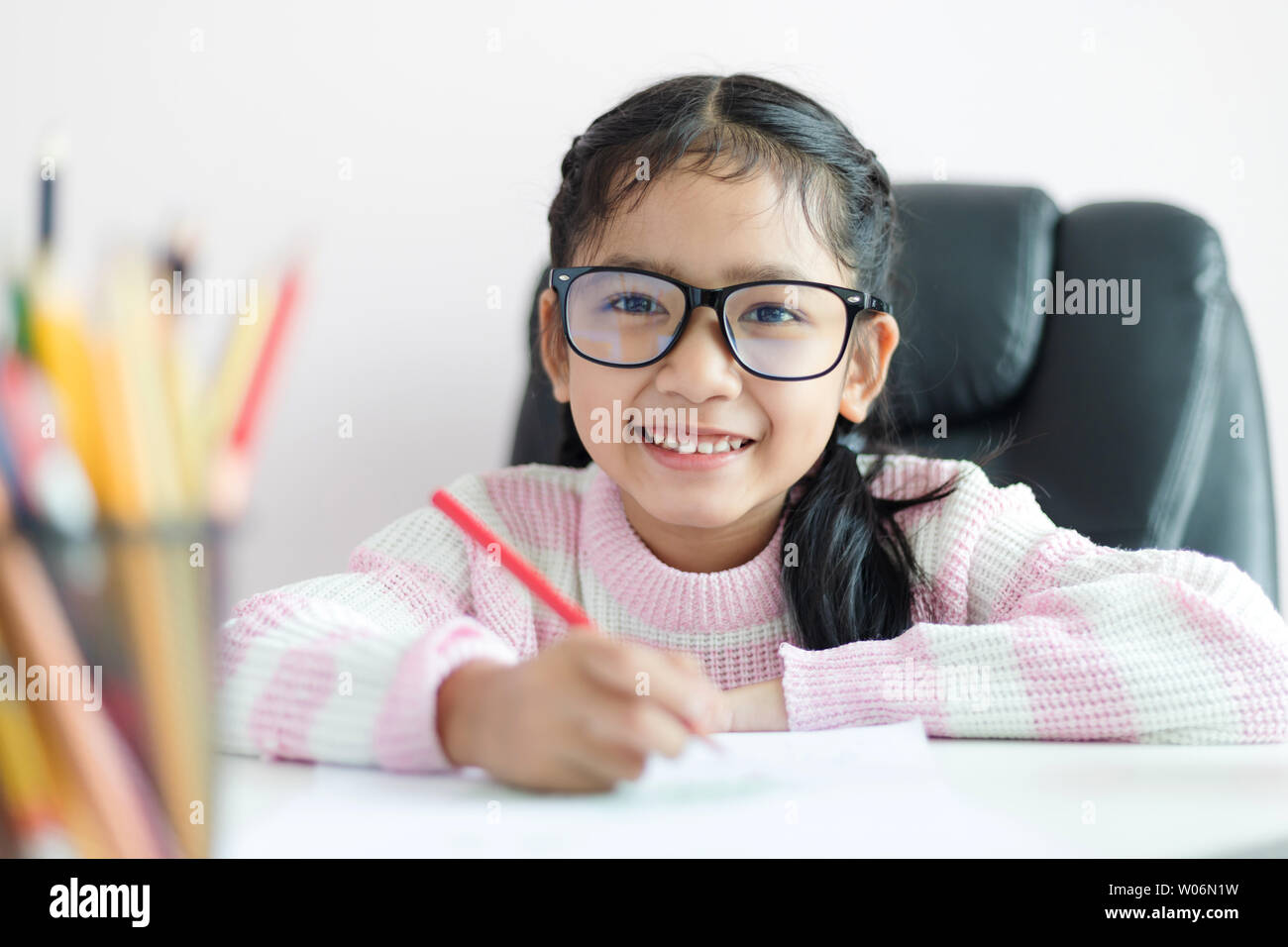 Little Asian girl doing homework and smile with happiness for education ...
