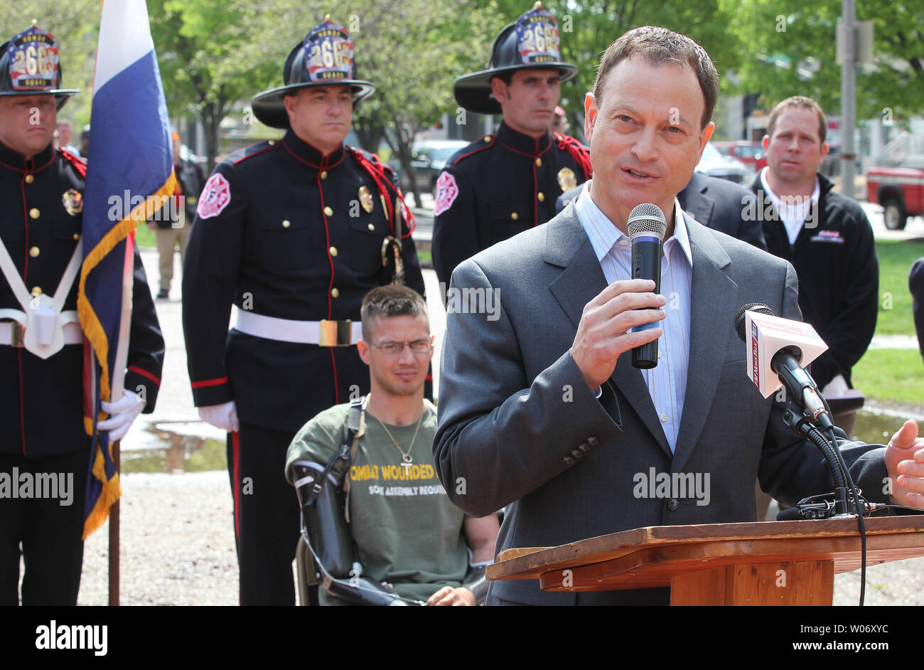 With a fire department honor guard standing near, actor Gary Sinise ...