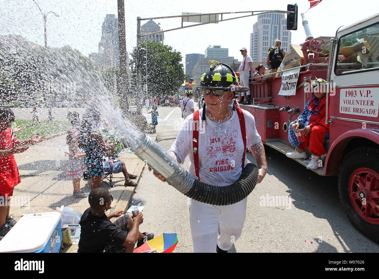 Members of the 1903 Volunteer Fire Brigade spray the crowd with ...