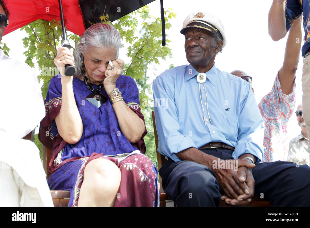Rock and Roll legend Chuck Berry listens to speakers as his wife Themetta, wipes away tears ...
