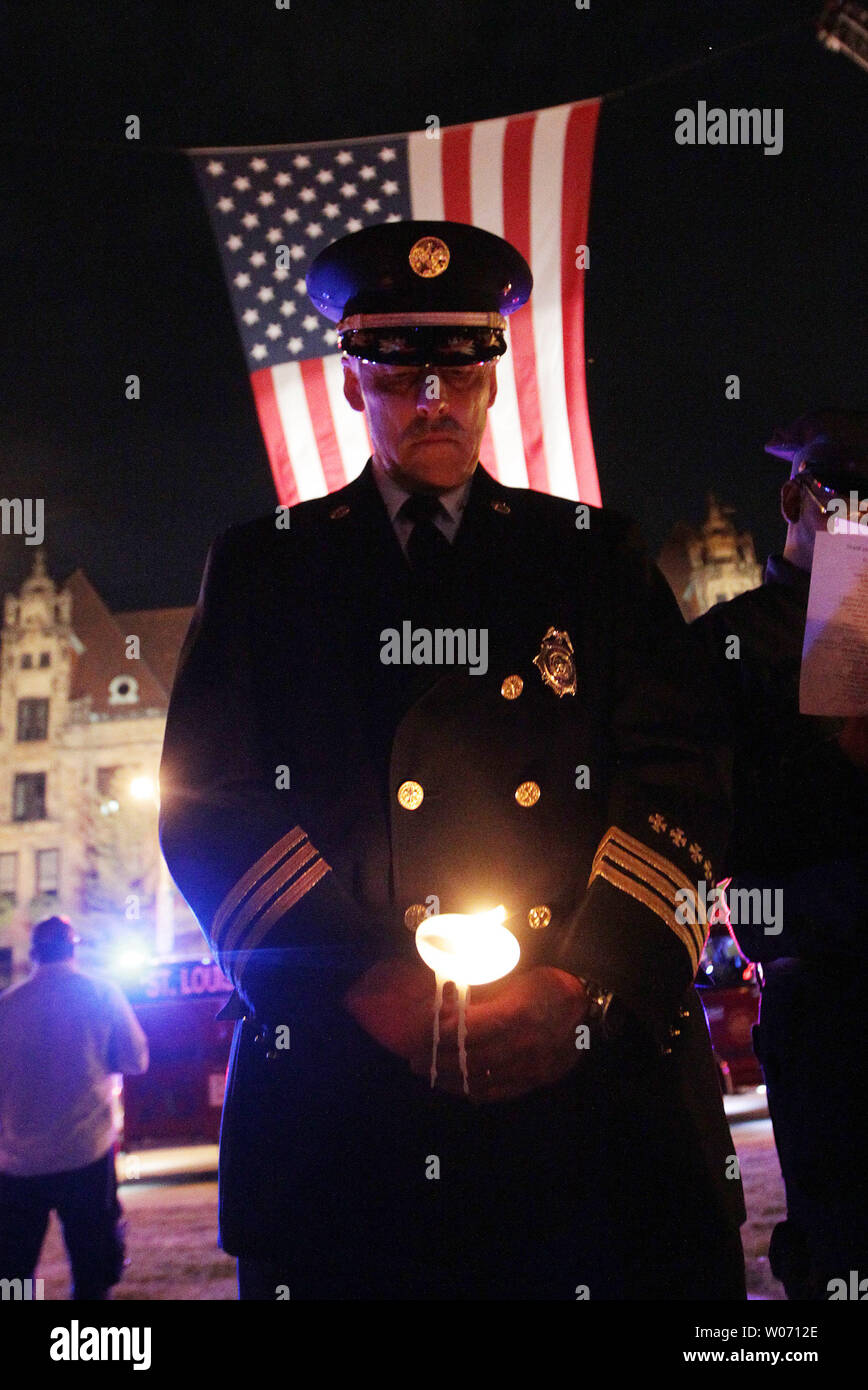St. Louis Fire Department Deputy Fire Chief Mike Arris holds a candle ...