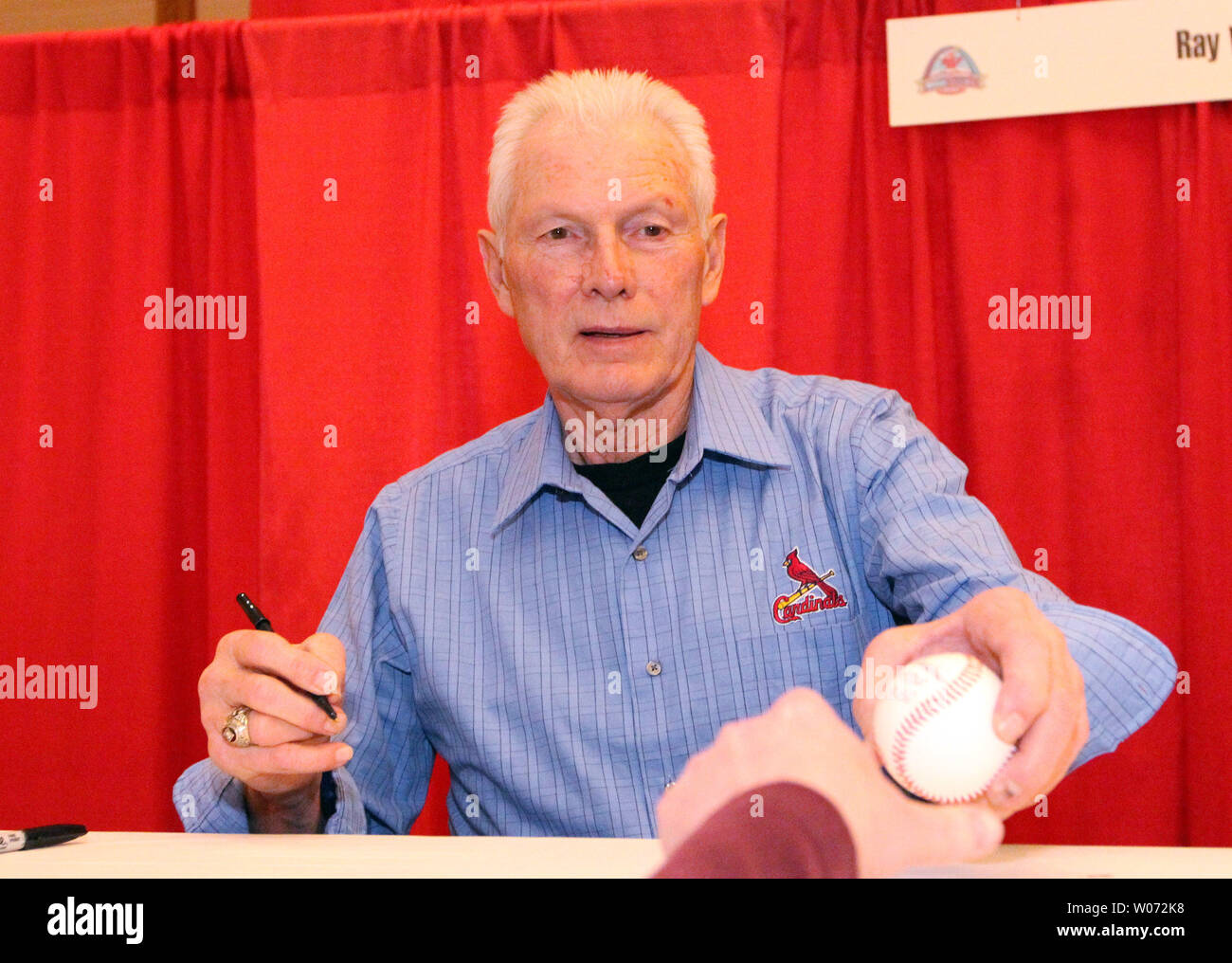 Former St. Louis Cardinals pitcher Ray Washburn signs an autograph for ...