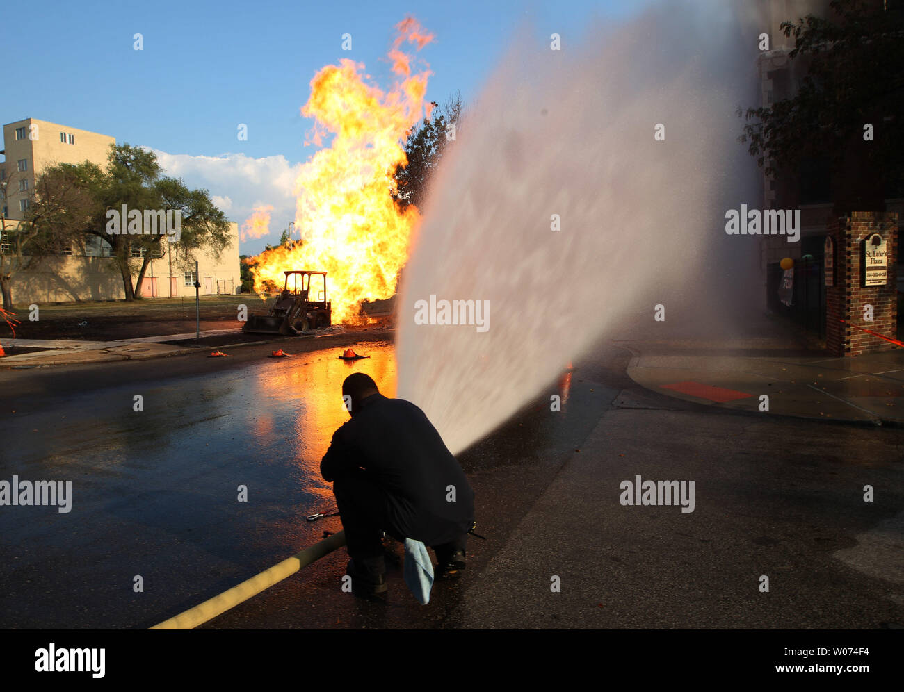 A St. Louis firefighter adjusts a master stream in an effort to protect ...