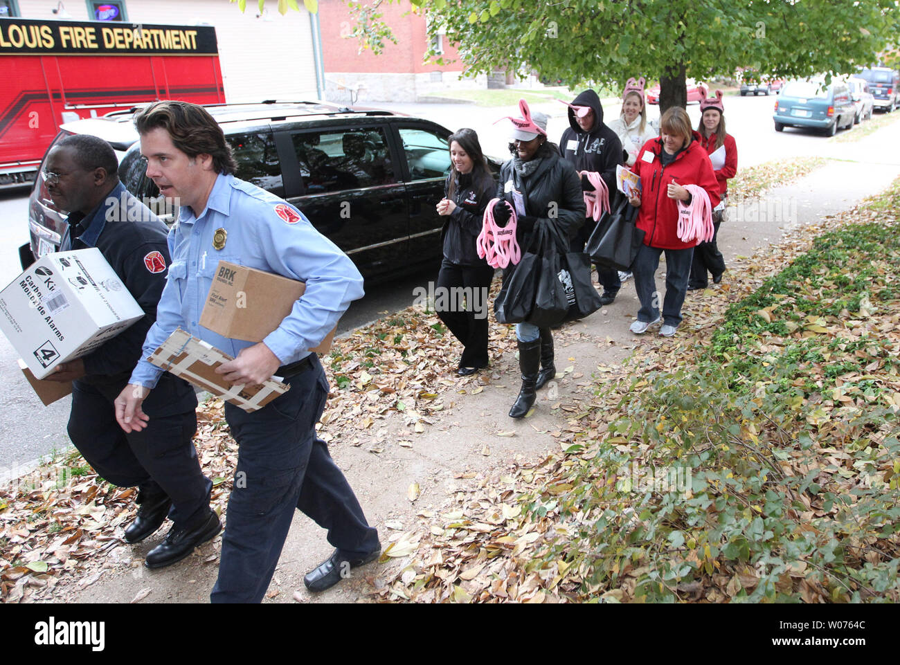 St. Louis firefighters along with volunteers go door to door to check ...
