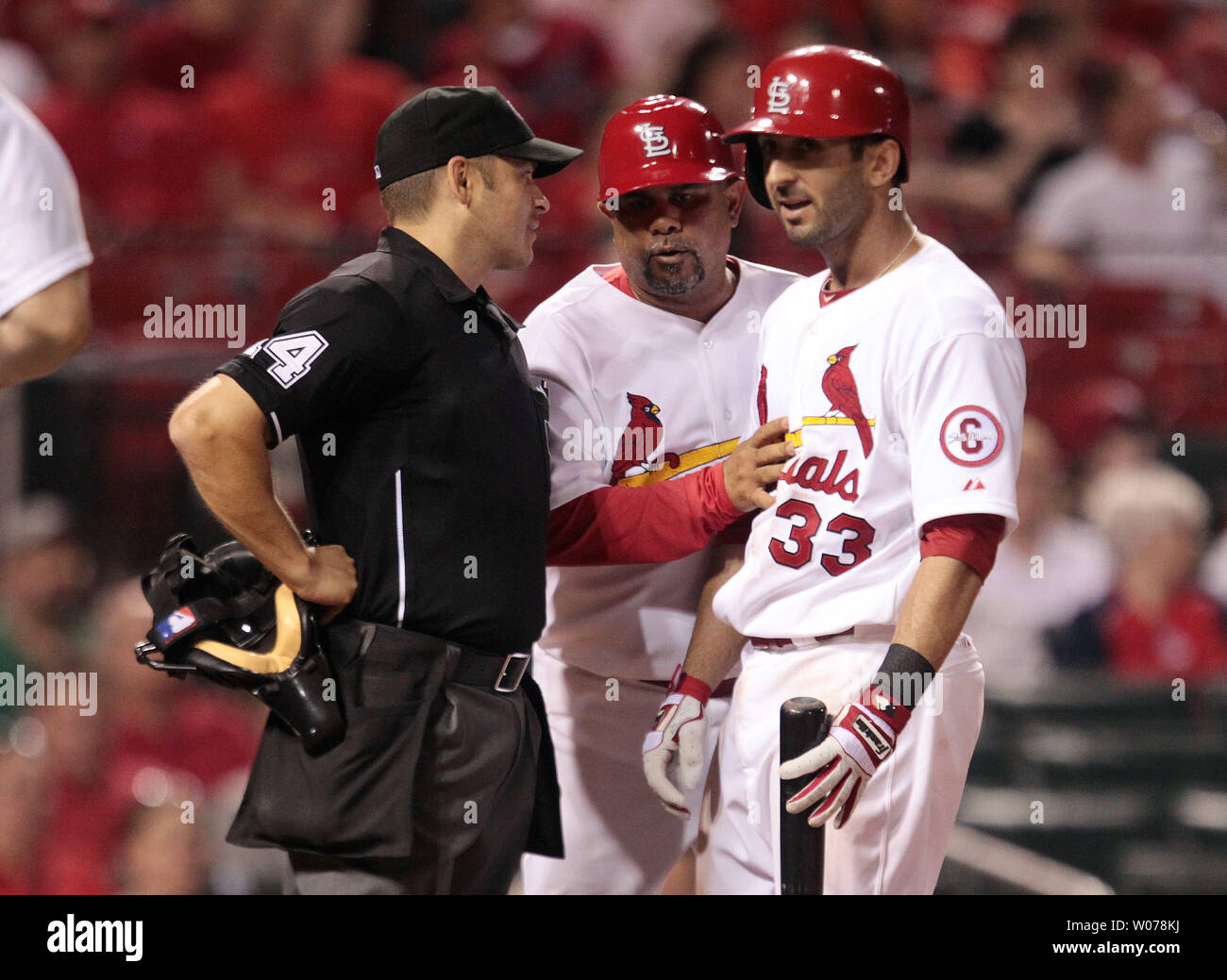St. Louis Cardinals third base coach Jose Oquendo gets between Daniel ...