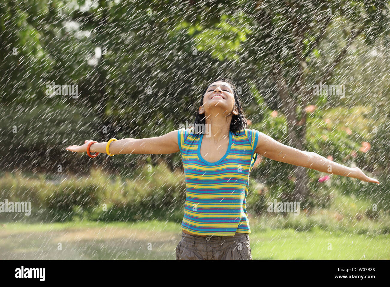 Indian young woman enjoying rain Stock Photo - Alamy