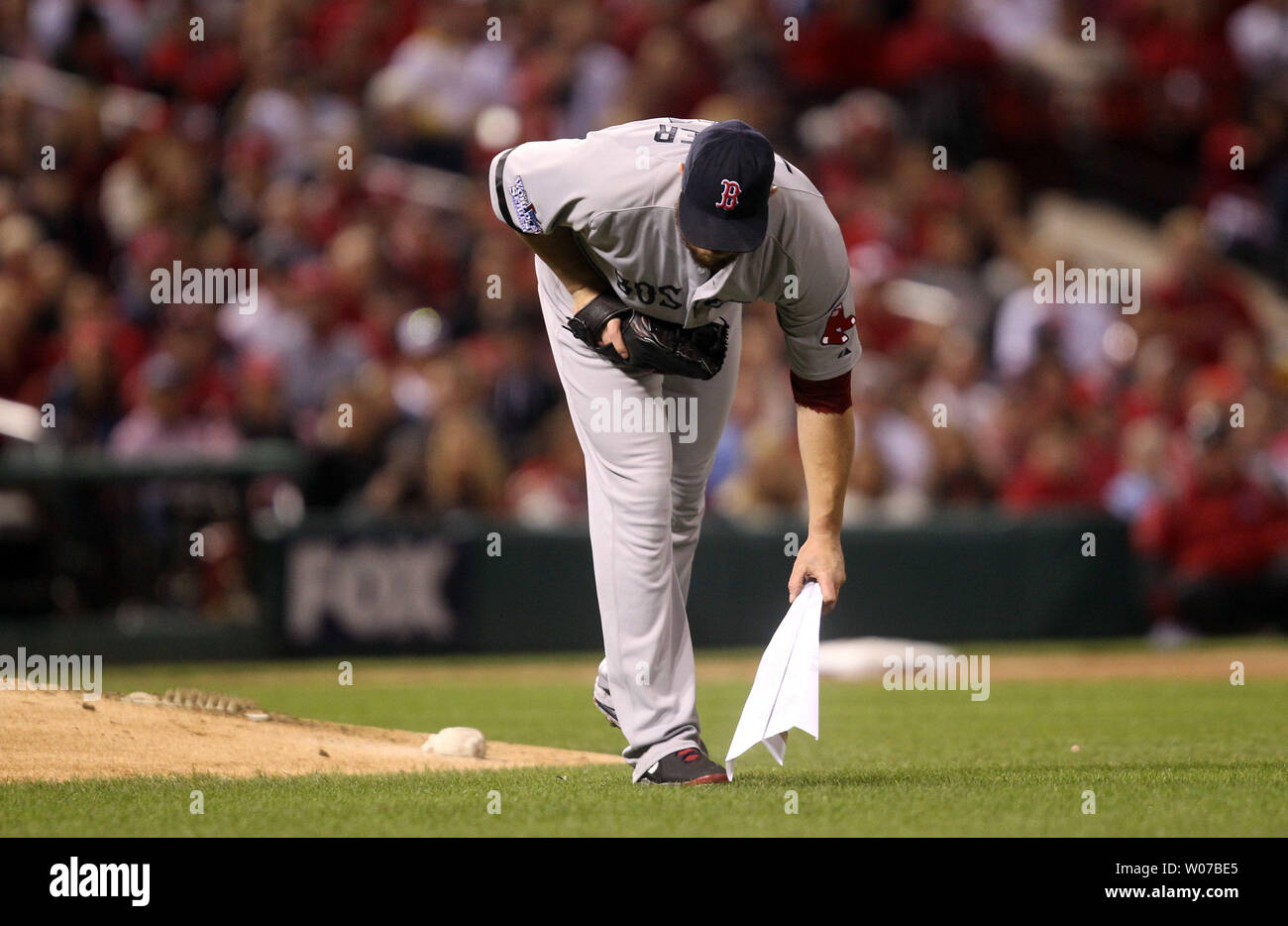 Boston Red Sox pitcher Jon Lester comes off of the mound to pick up a ...