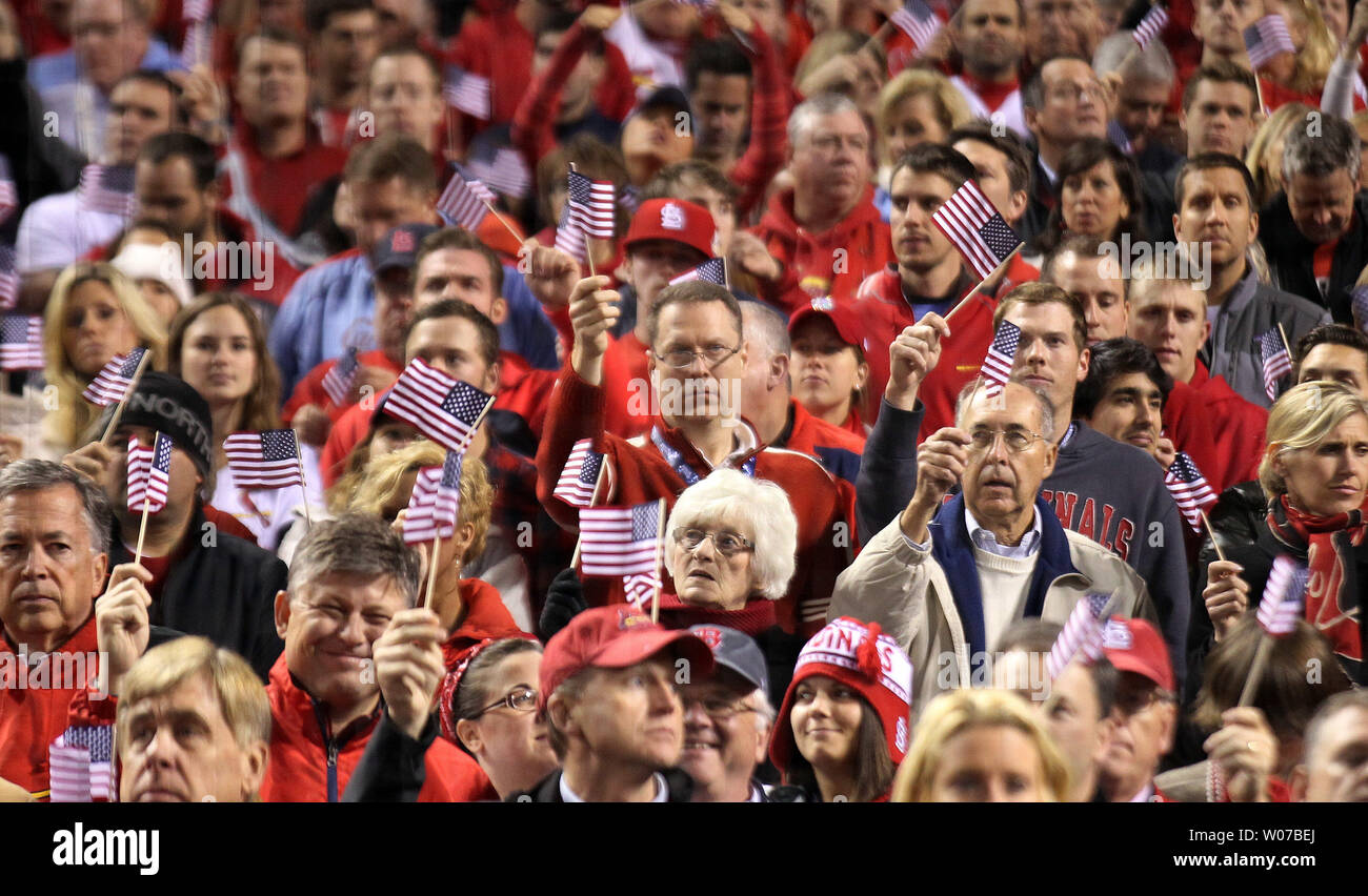 Baseball fans wave American flags during the singing of "God Bless ...