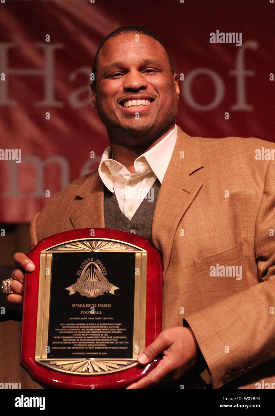 Former St. Louis Rams D'Marco Farr smiles as he accepts his award ...