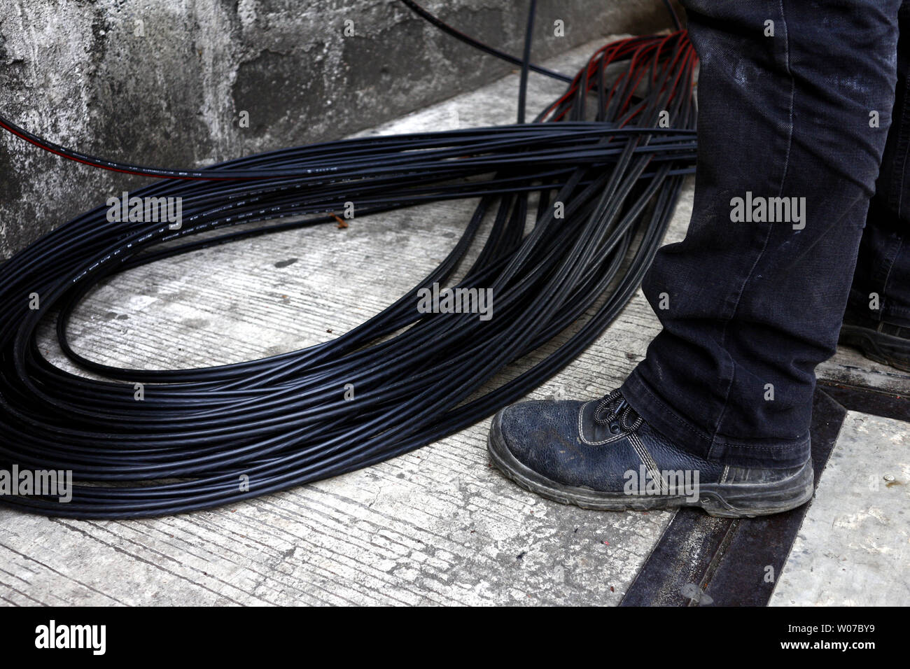 Photo of feet of construction worker wearing safety shoes standing next ...