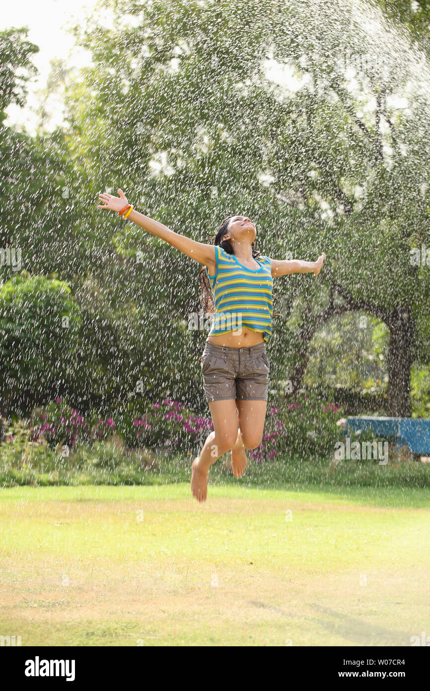 Woman jumping in rain Stock Photo - Alamy