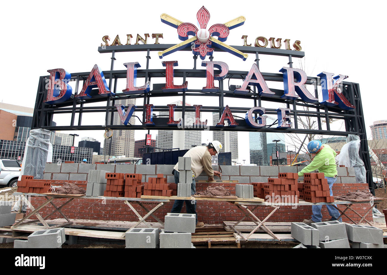 Brick layers put the finishing touches on a sign for Ballpark Village ...