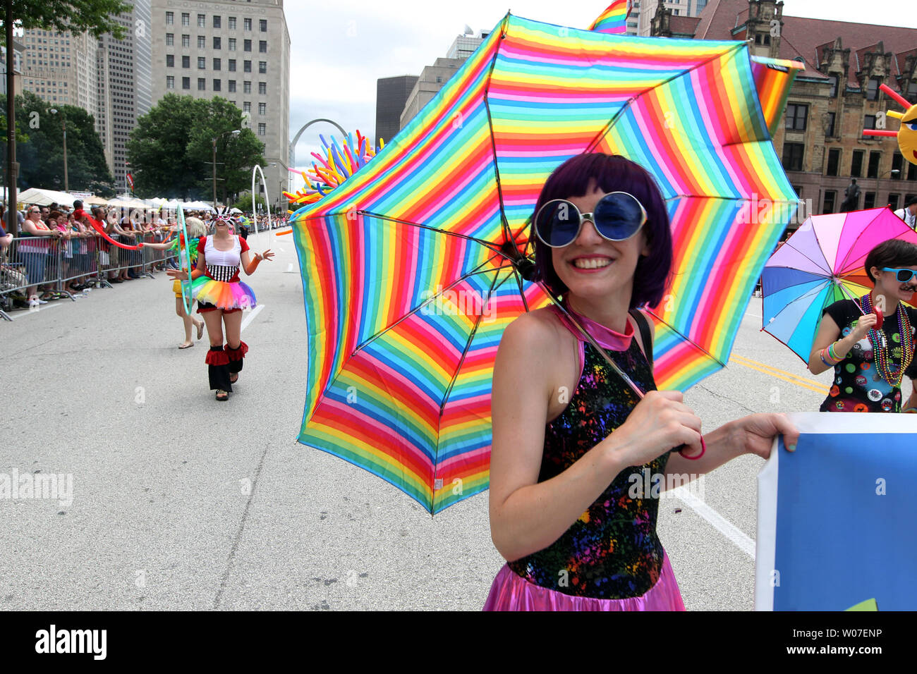 A parade participant marches with a colorful umbrella during the ...