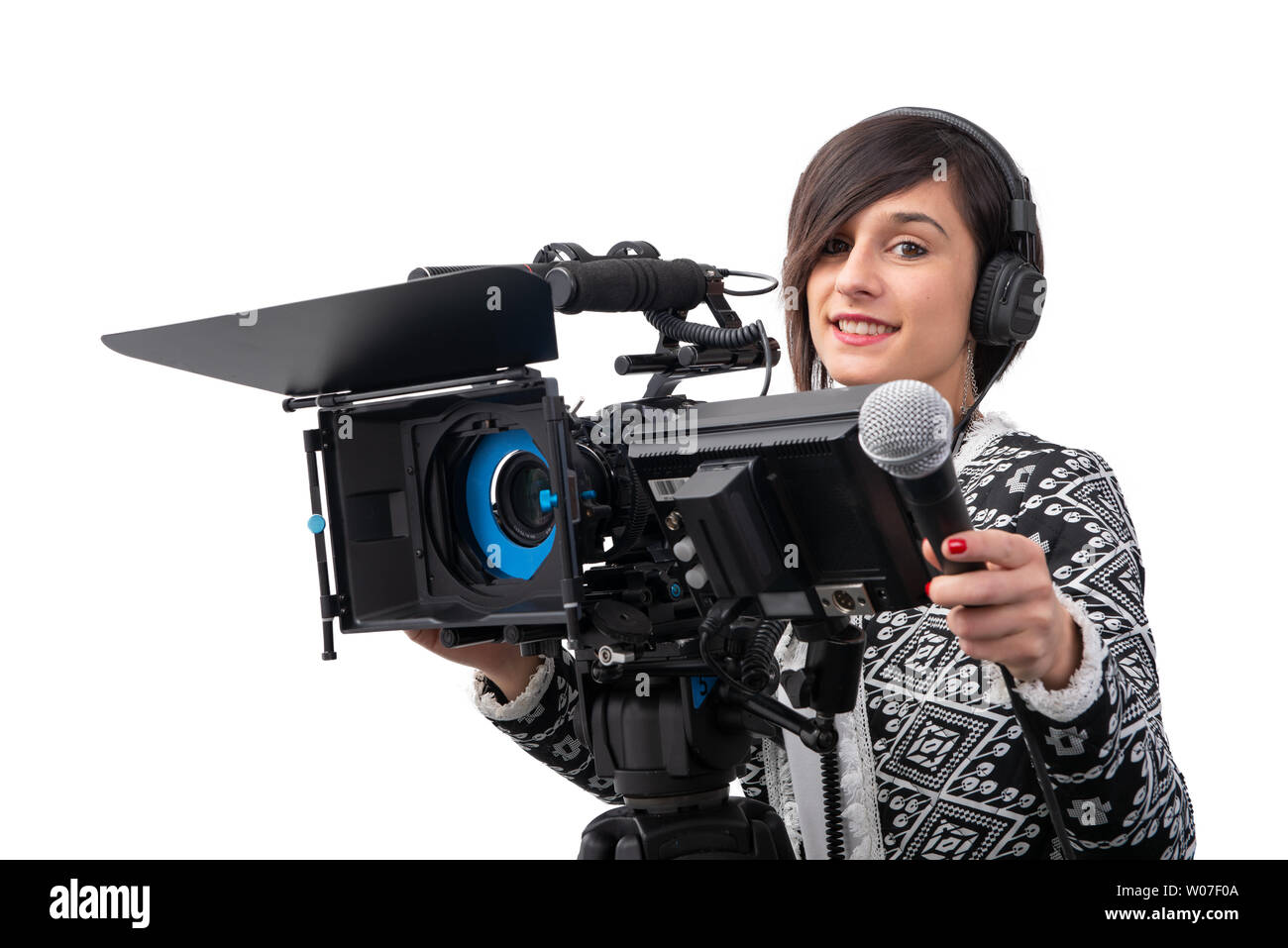 a pretty young woman journalist with microphone and camera in ...