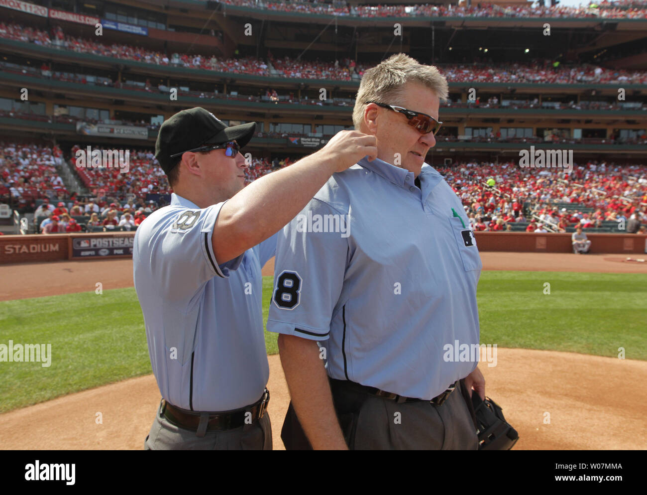 First base umpire Quinn Wolcott corrects the collar of home plate ...