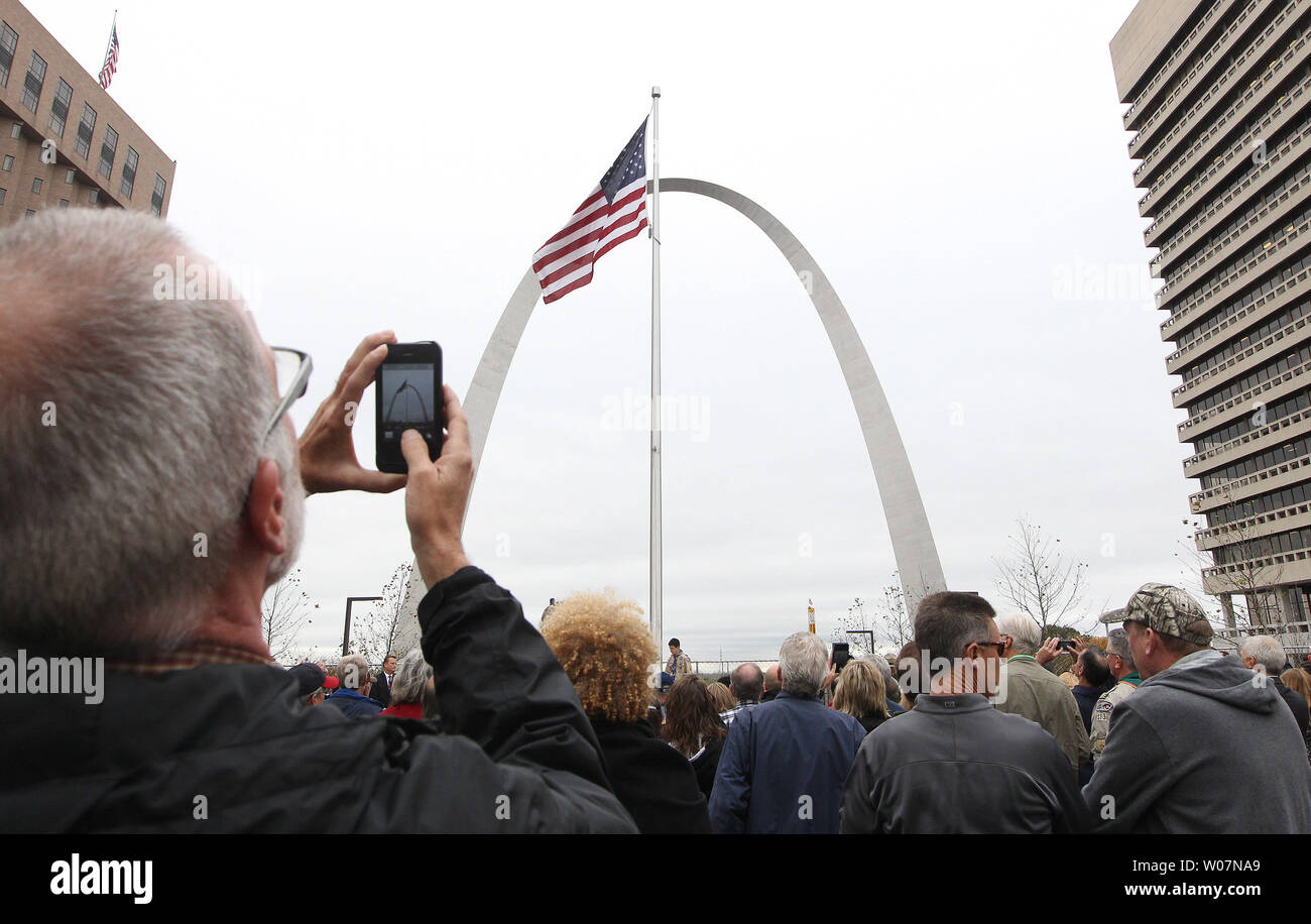 A visitor to the Gateway Arch photographs flag raising ceremonies ...