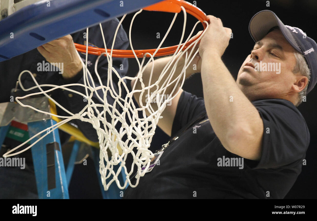 Scottrade worker David Grimes tries to reattach the net to the hoop ...