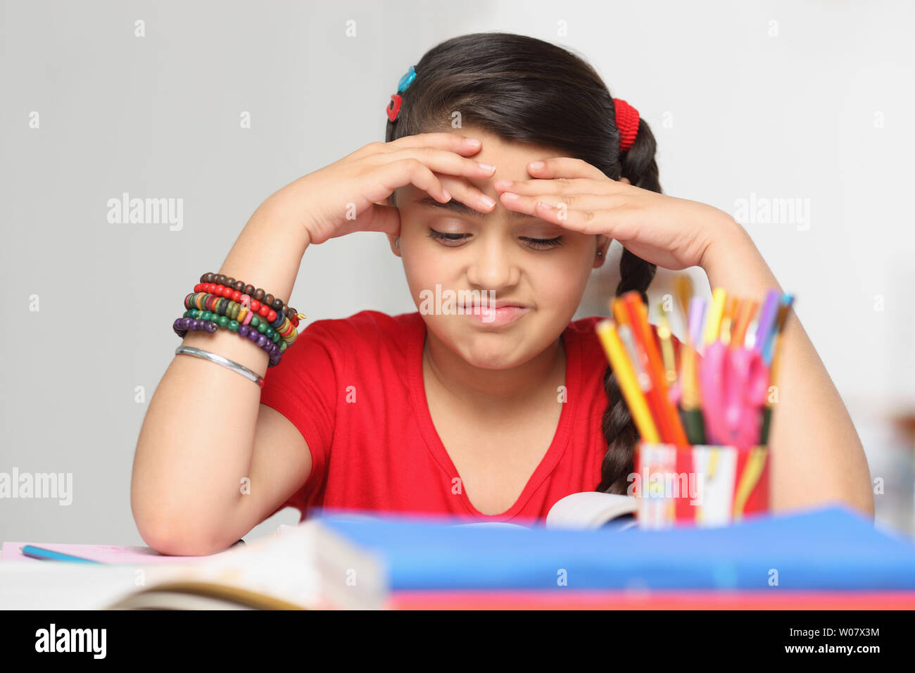 Indian girl looking sad while doing her homework Stock Photo - Alamy