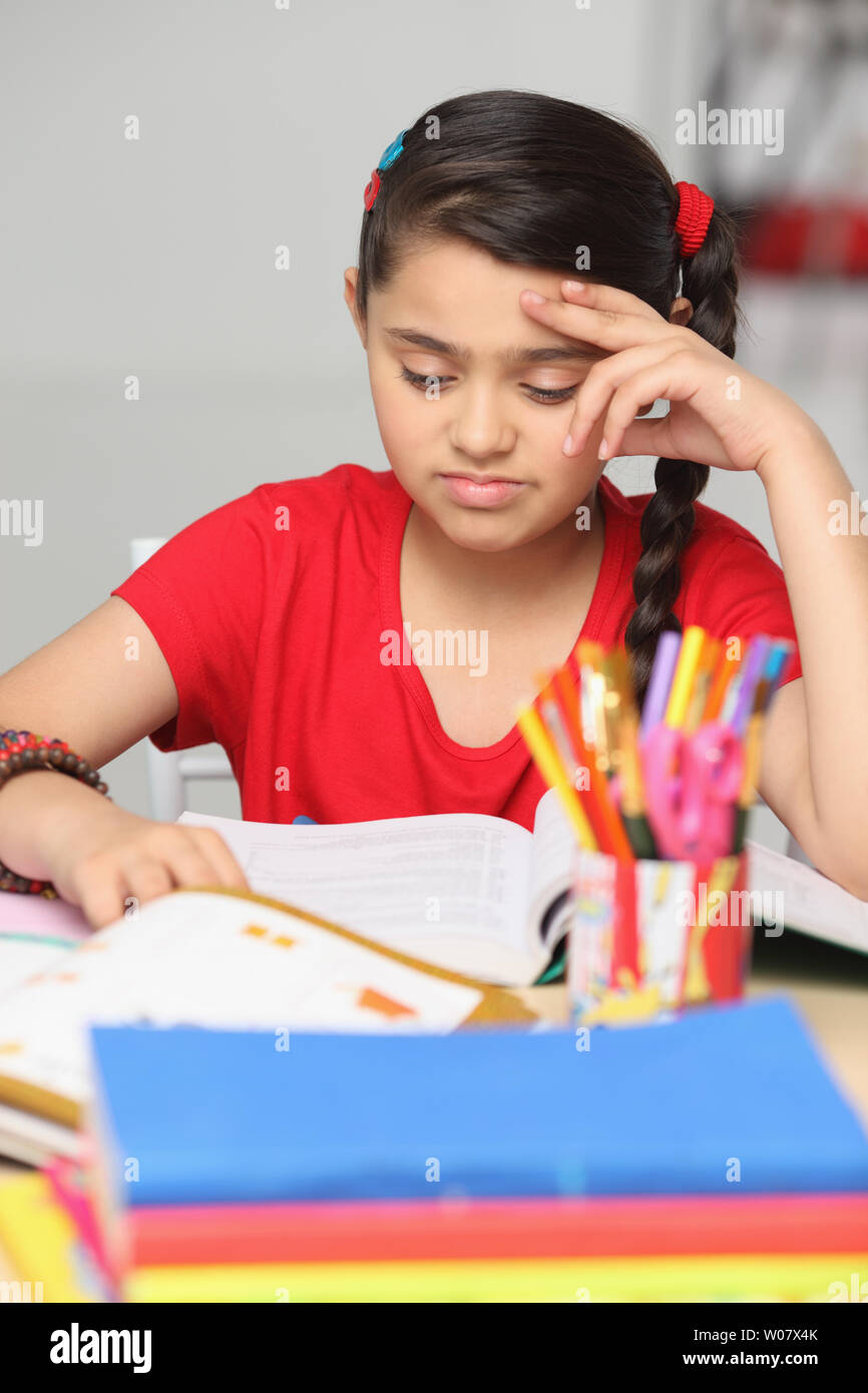Girl looking sad while doing her homework Stock Photo - Alamy