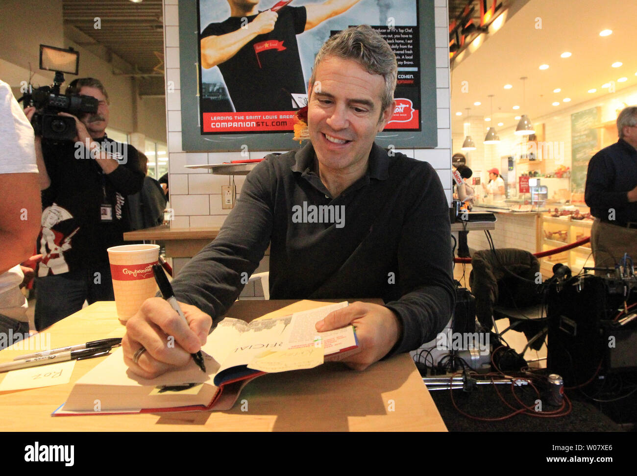 Talk show host Andy Cohen signs a copy of his new book "Superfical ...
