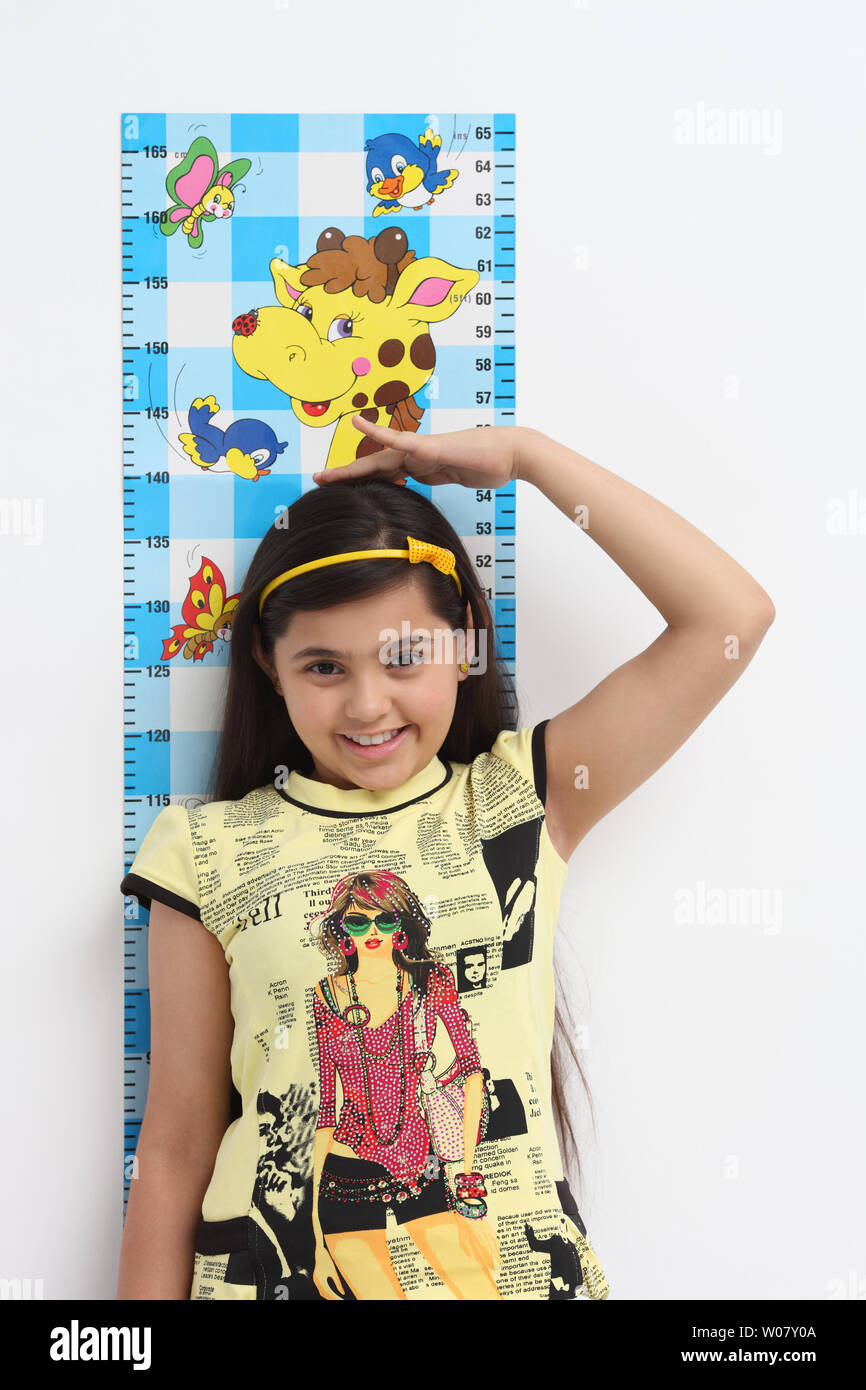 Portrait of an Indian girl measuring her height Stock Photo - Alamy