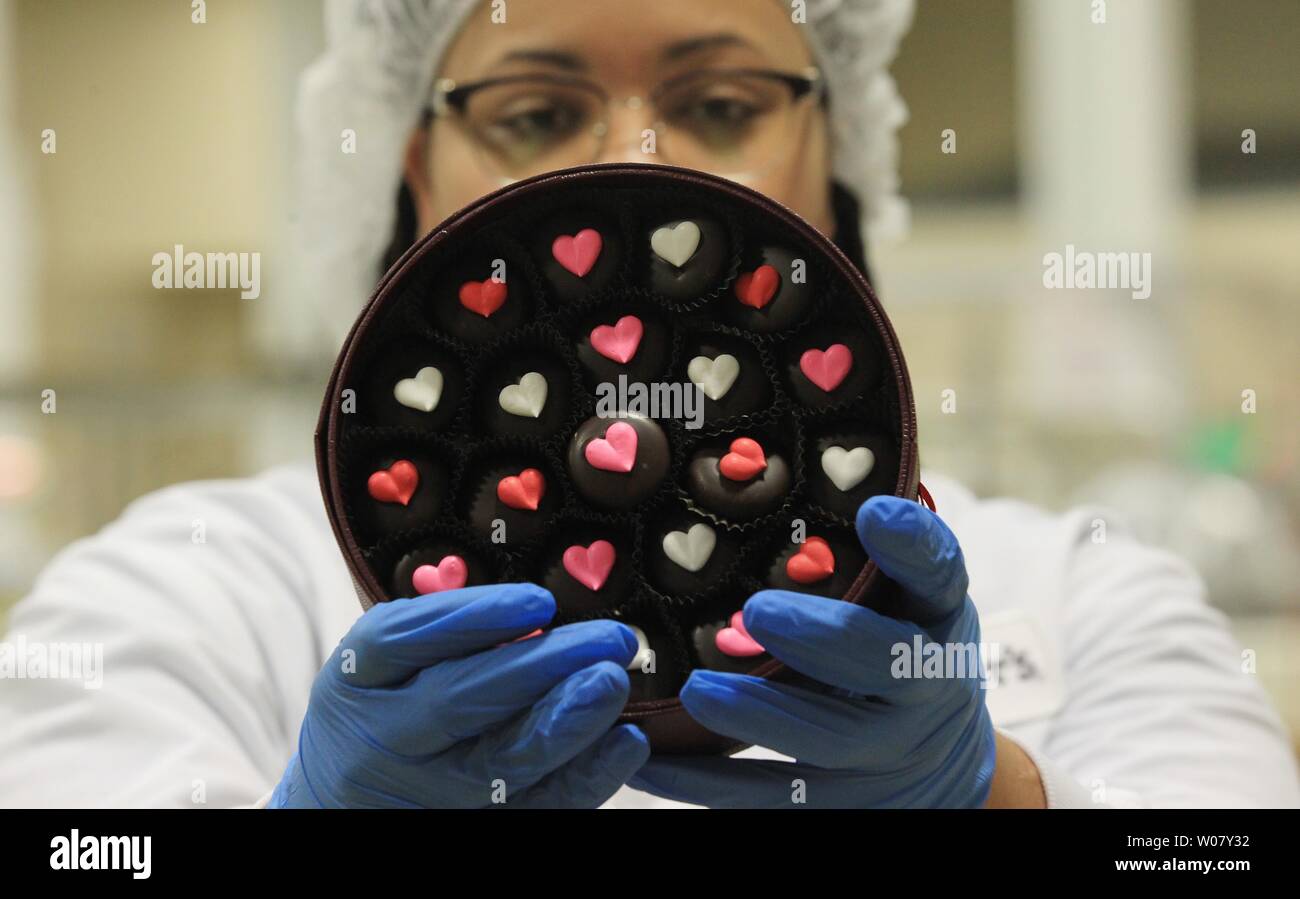 Candy line worker Essence Carter checks packaging on a box of ...