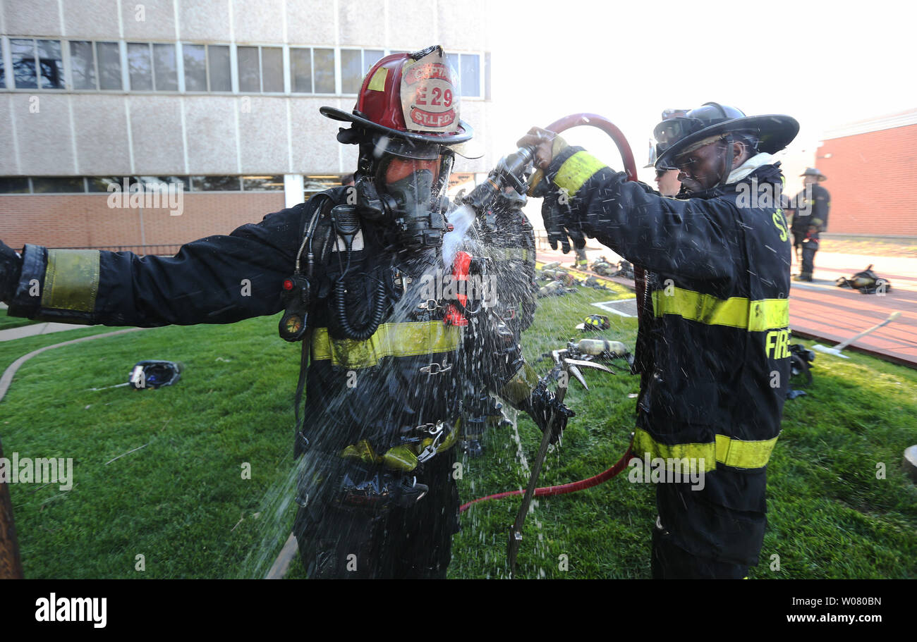 St. Louis firefighters are rinsed off after fighting a three alarm fire ...
