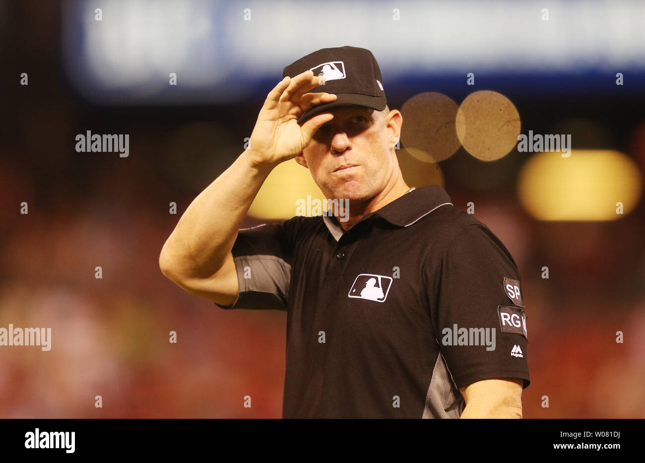 First base umpire Jim Wolf adjusts his cap between innings of the ...