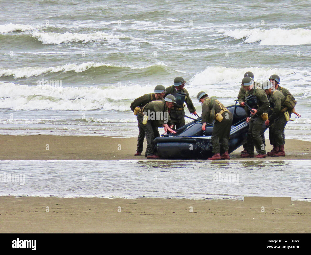 UTAH, FRANCE - June 06, 2019. Special forces men in camouflage uniforms out army kayak on beach ...