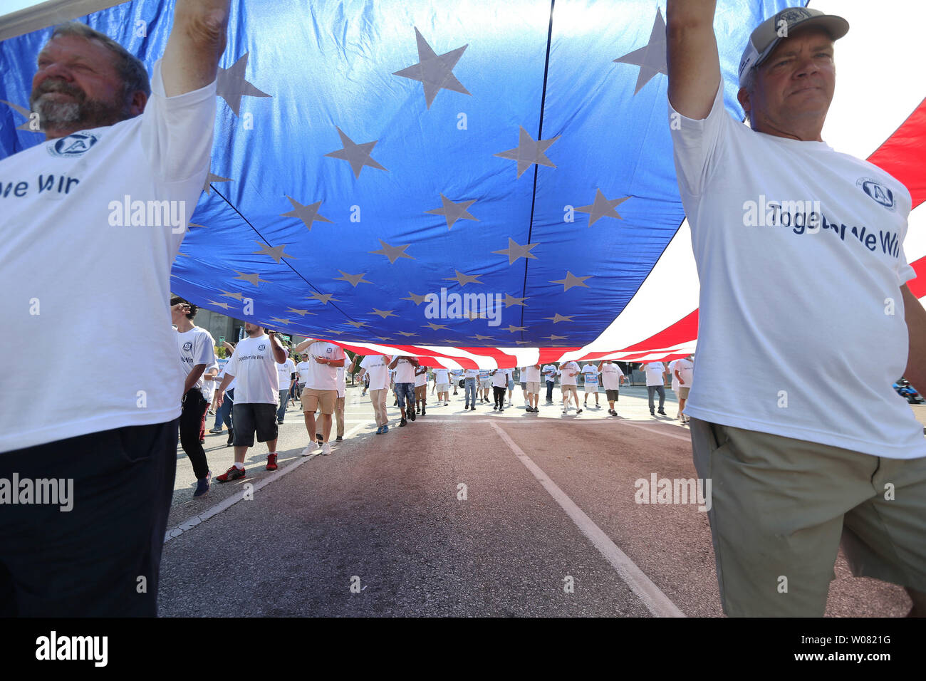 Painter's union members carry a large, oversized Ameican flag during ...