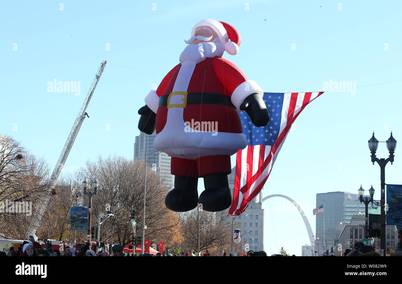 An inflatable Santa Clause balloon is towed in the Christmas in St ...