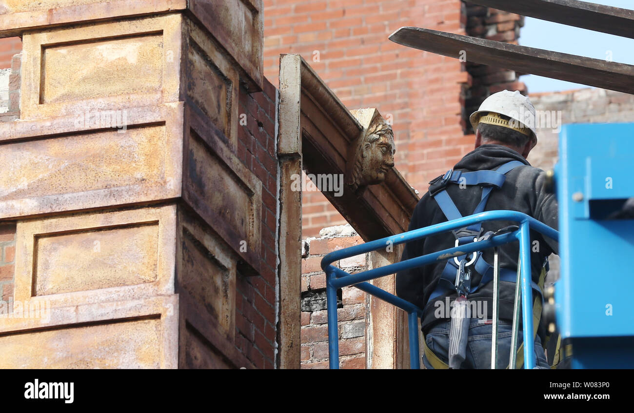 A construction workers examines a cast iron face piece on a window ...